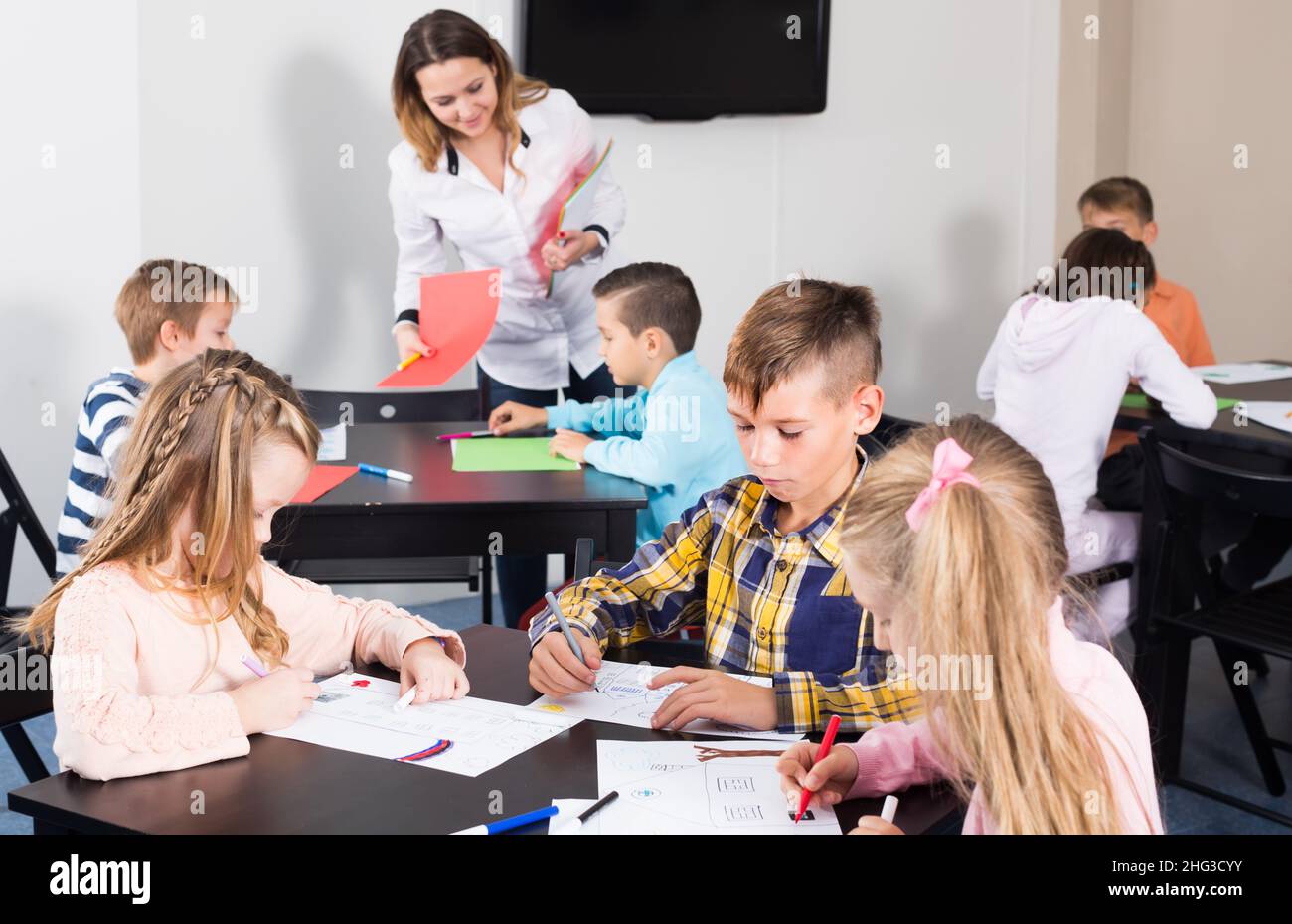 Group of children in elementary age drawing at classroom Stock Photo ...