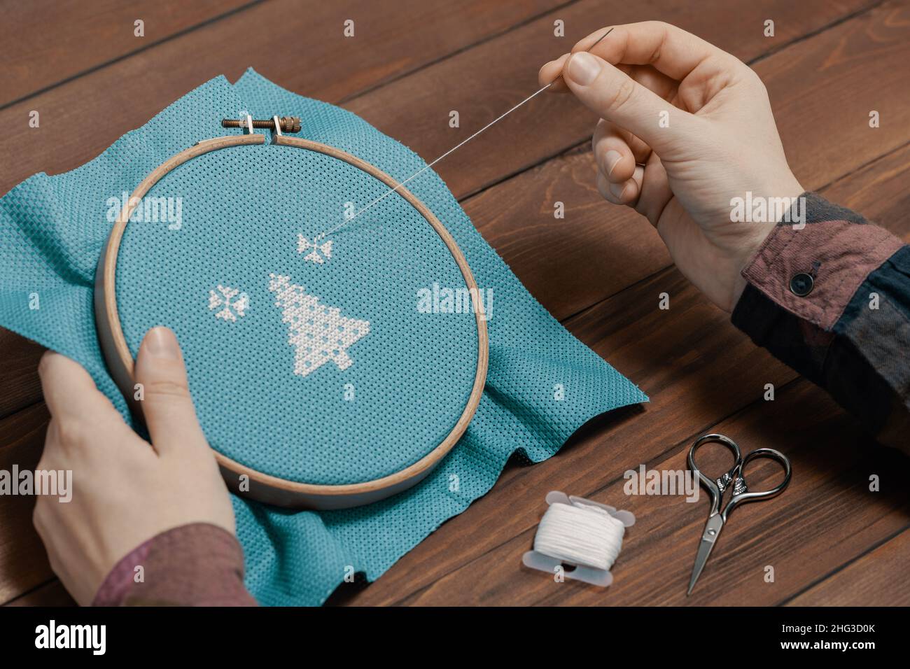 Craftsperson holding needle with stretching thread in her hand Stock ...