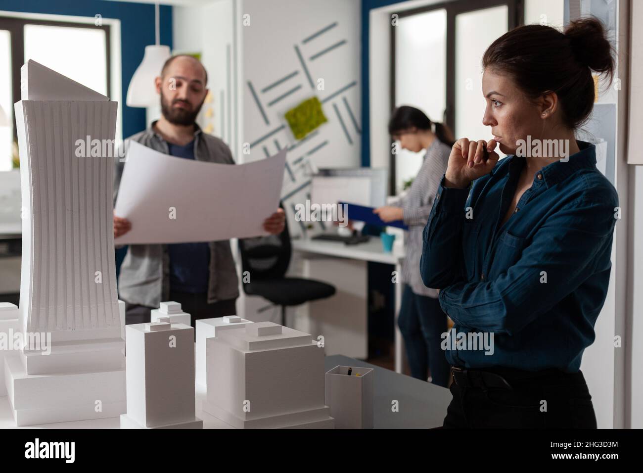 Architect looking into the distance gazing at skyscraper scale model ...