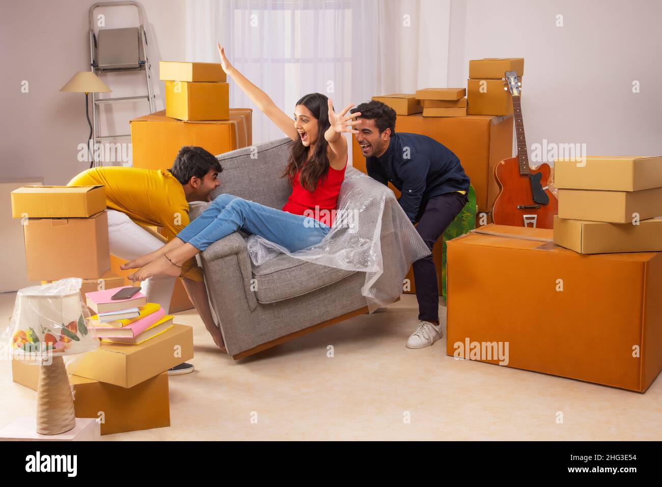 Adult boys and girl having fun during house shifting Stock Photo - Alamy