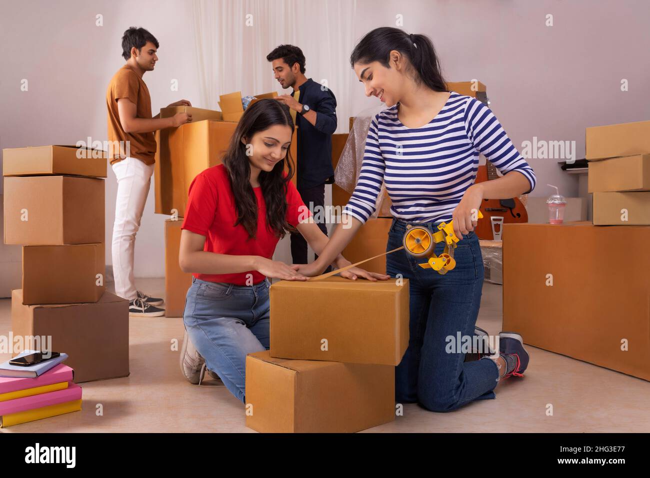 Girls packing cardboard boxes and the boys checking carton box Stock ...