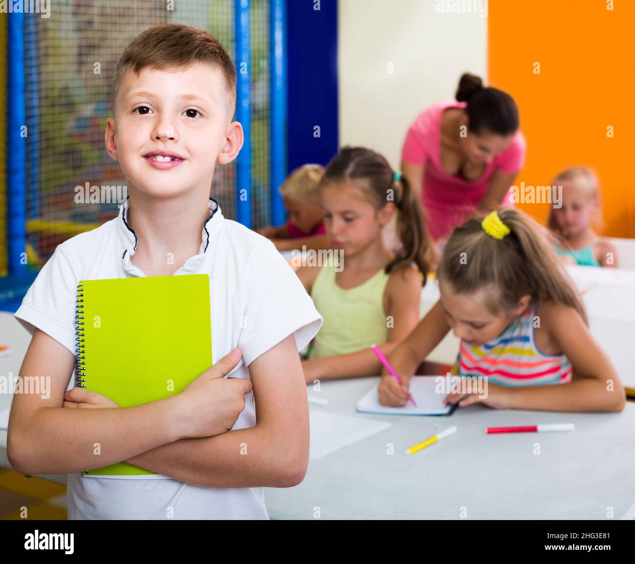 Portrait of boy holding notepad in school class Stock Photo - Alamy