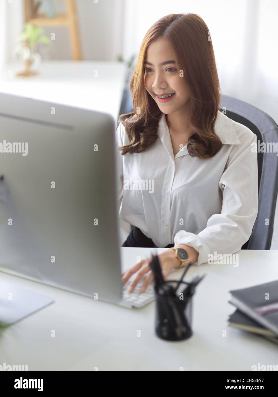 Beautiful Asian young female assistant or secretary working on her ...