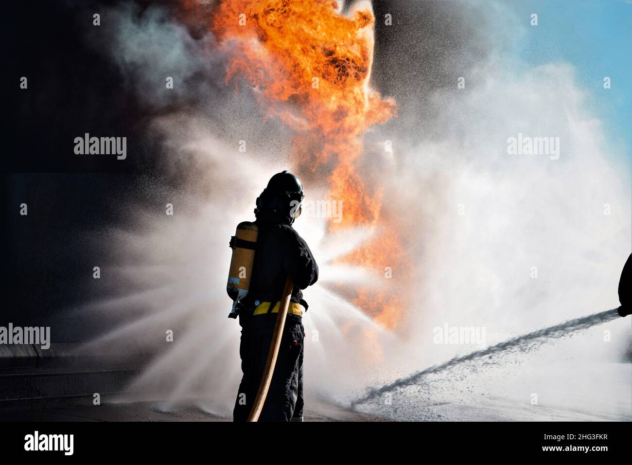 Group of firefighters putting out a fire surrounded by smoke Stock ...