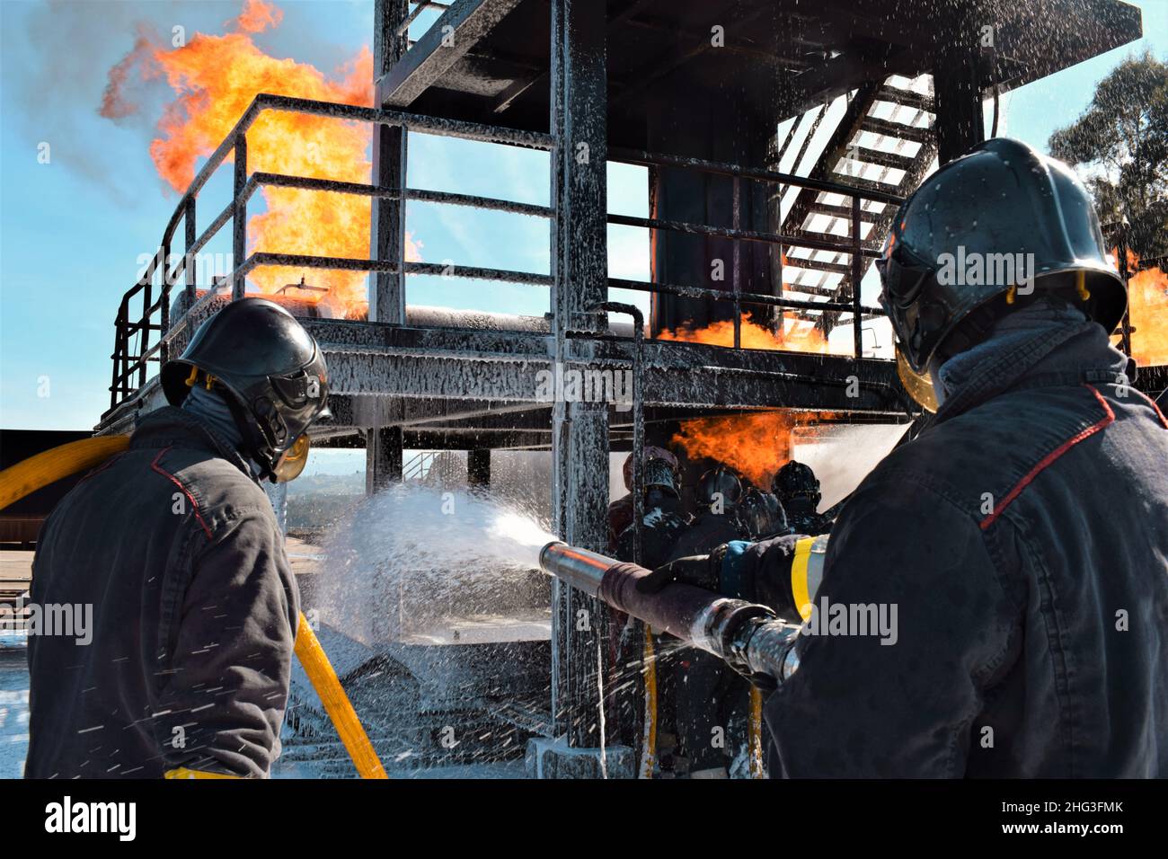 Group of firefighters putting out a fire surrounded by smoke Stock ...