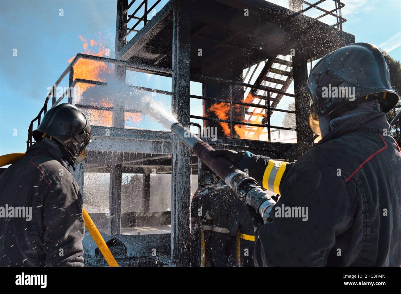 Group of firefighters putting out a fire surrounded by smoke Stock ...