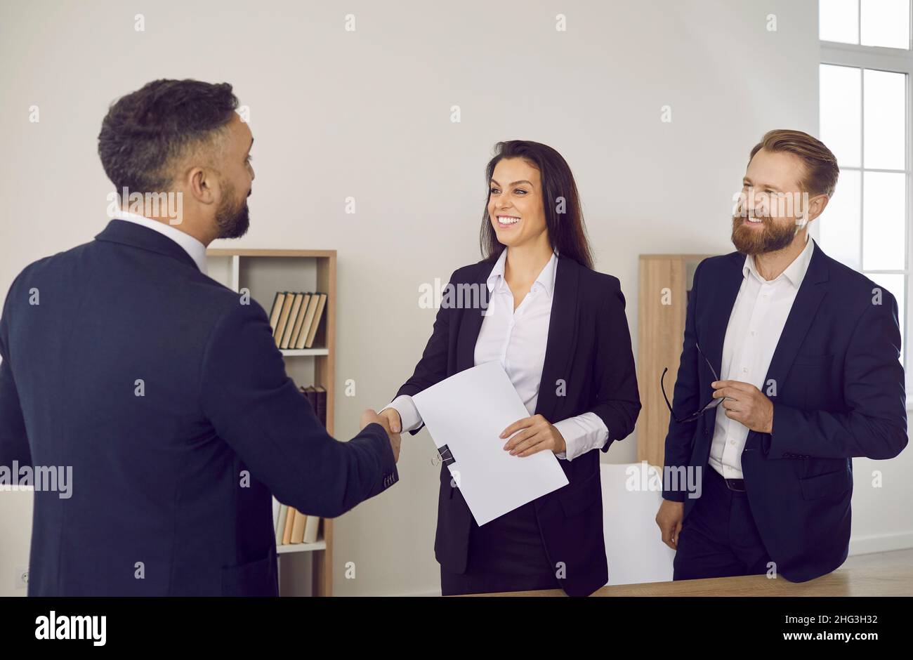 Happy clients exchanging handshake with professional lawyer or ...