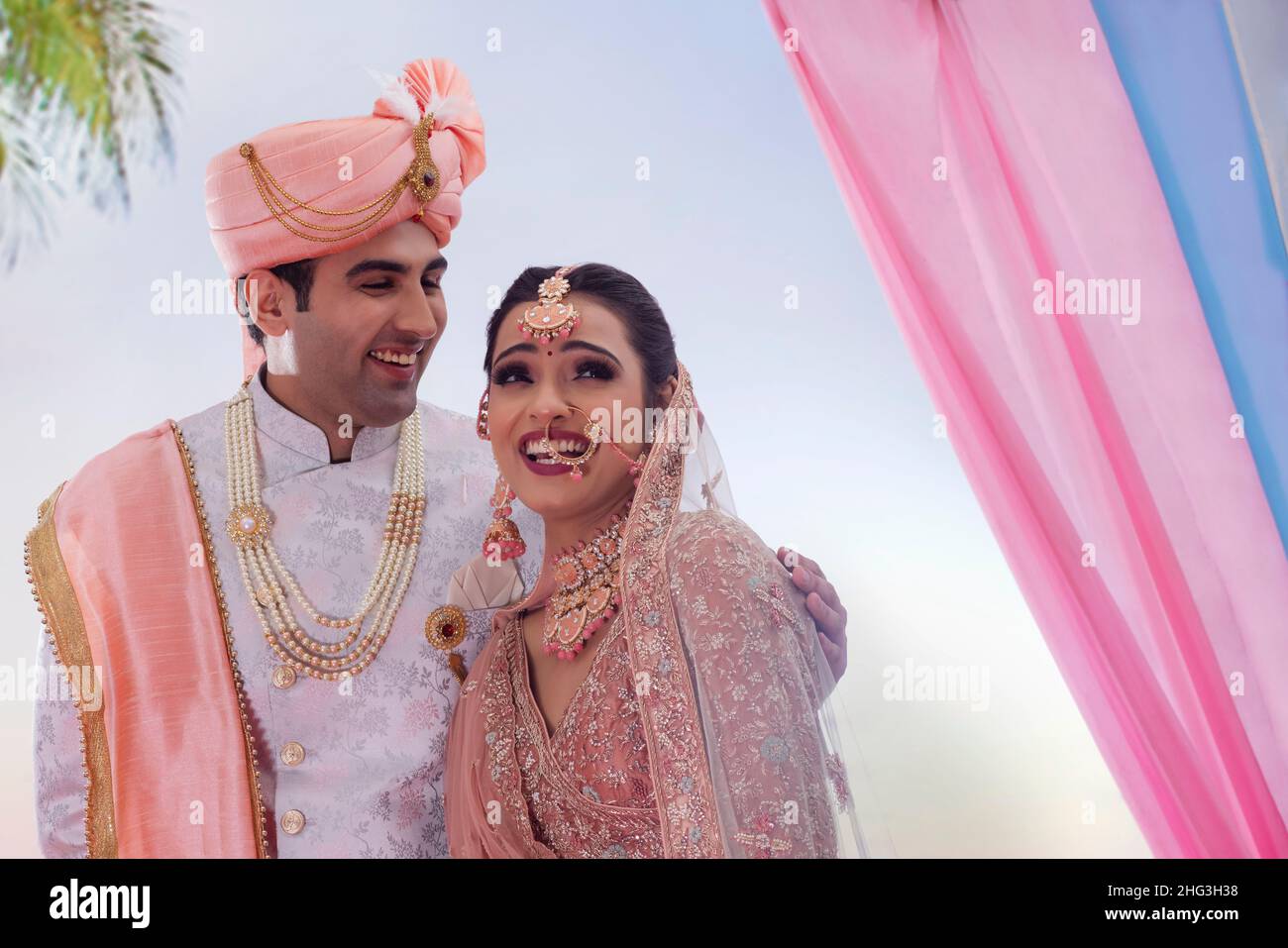 Indian bride and groom in traditional wedding dress smiling together ...