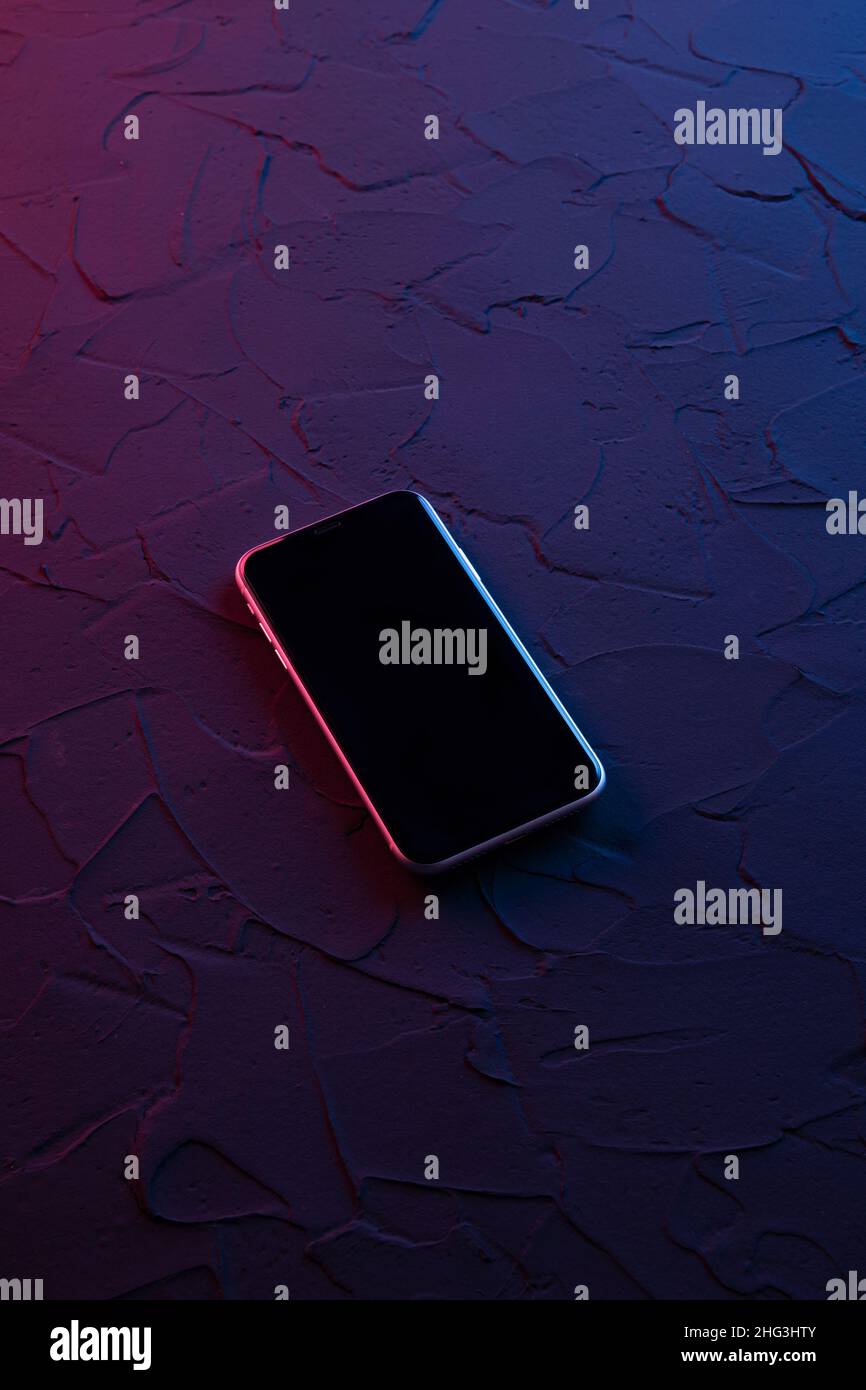 Mobile smartphone on dark red blue neon colors. Mock up.Perspective ...
