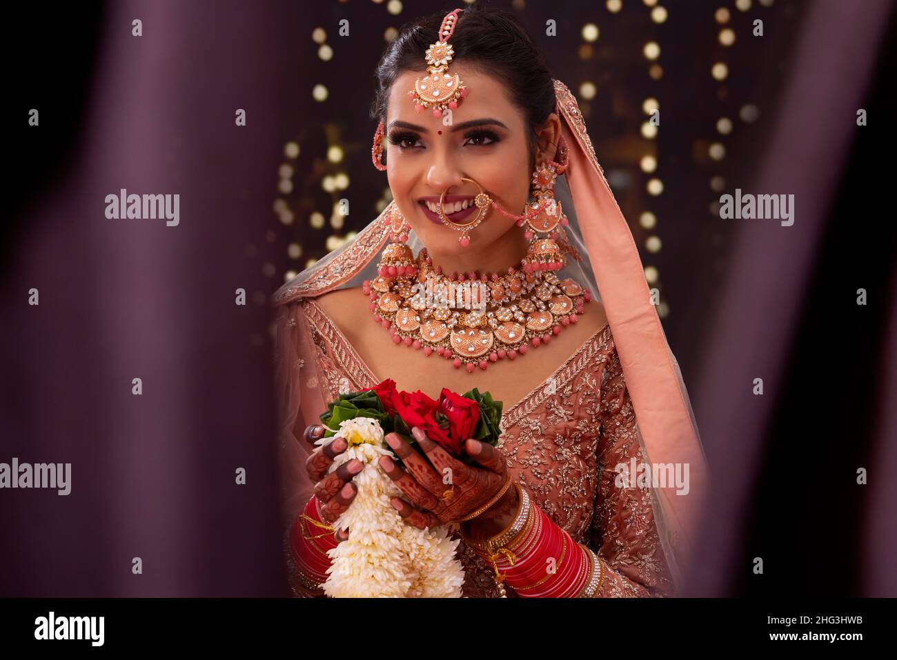 Indian bride in traditional wedding outfit holding garland Stock Photo ...
