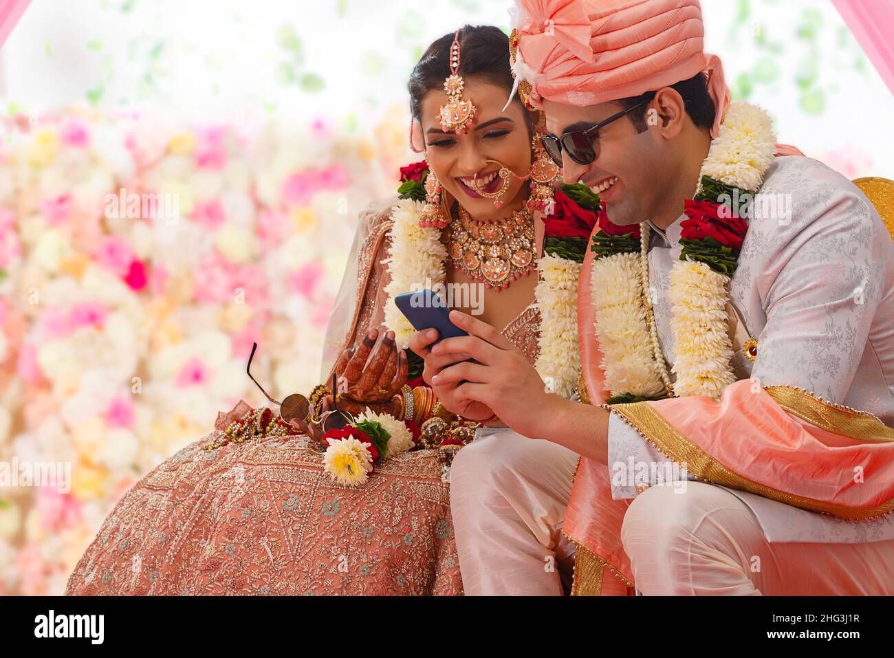 Bride and groom watching Smartphone together while sitting on wedding ...