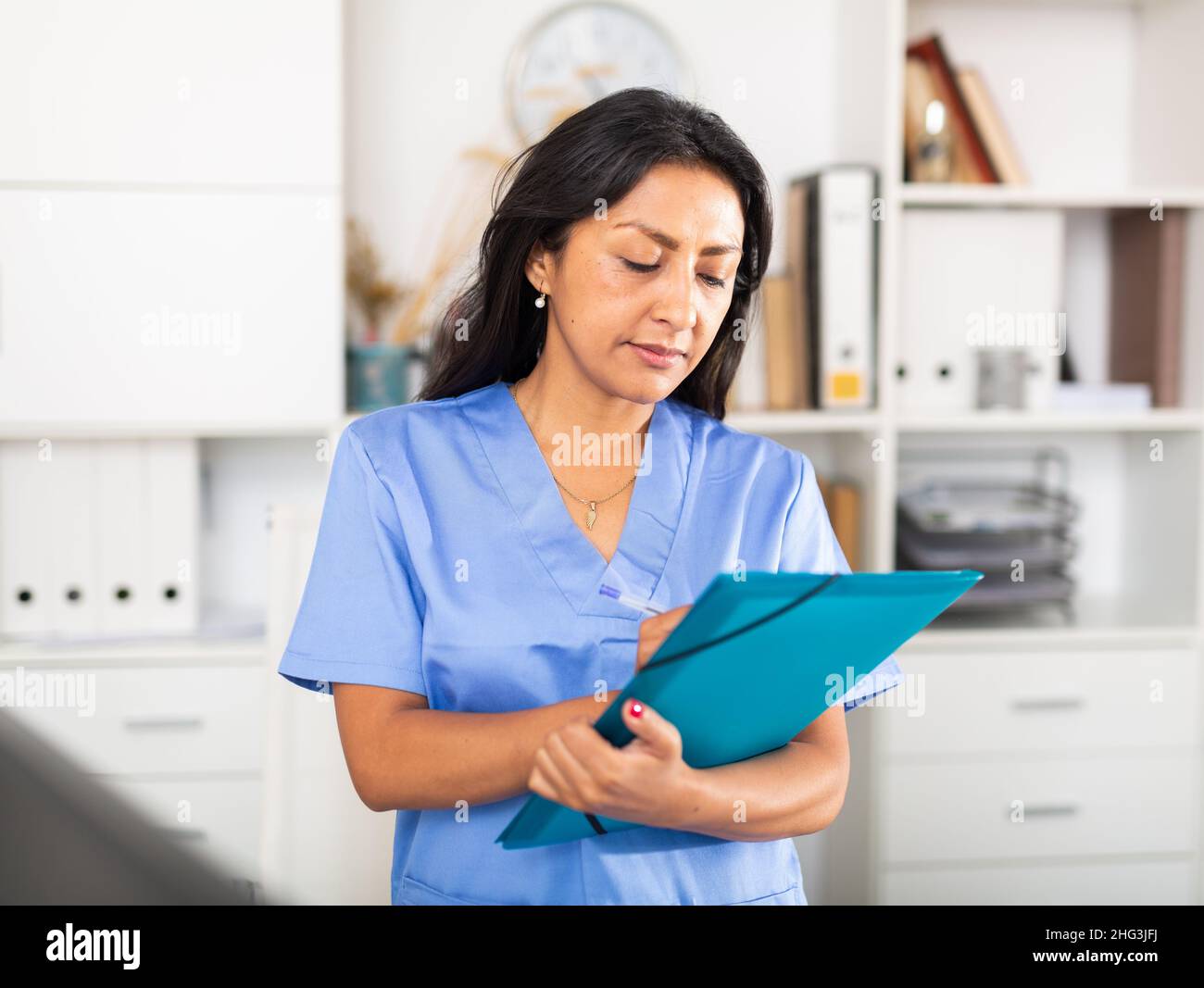 Woman doctor filling out clipboard with medical records Stock Photo - Alamy