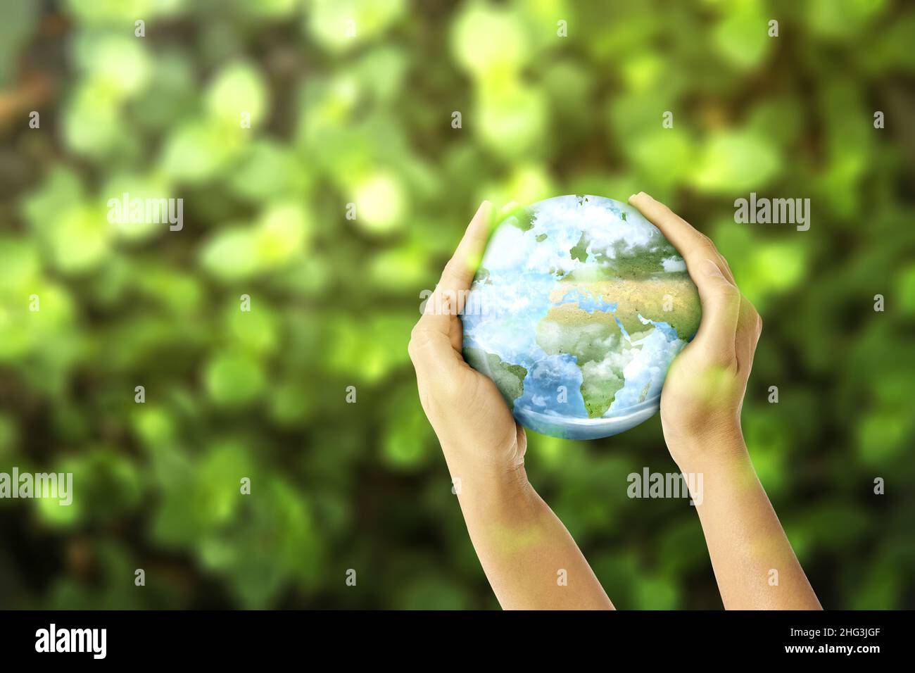 Hand holding the earth with blurred light background. World environment ...