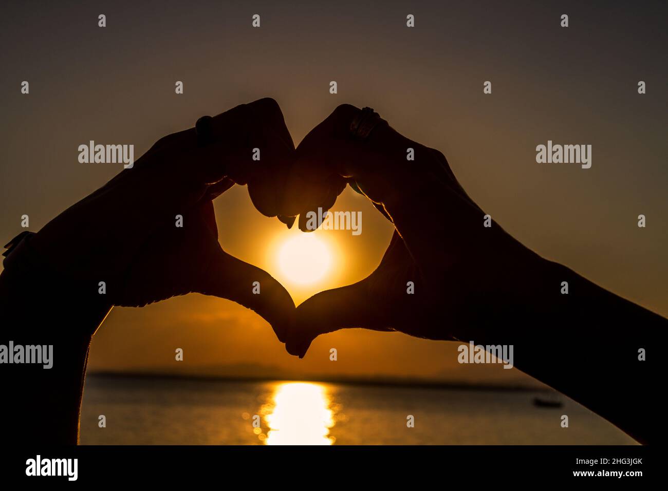 hand forming a heart around the sun Stock Photo - Alamy