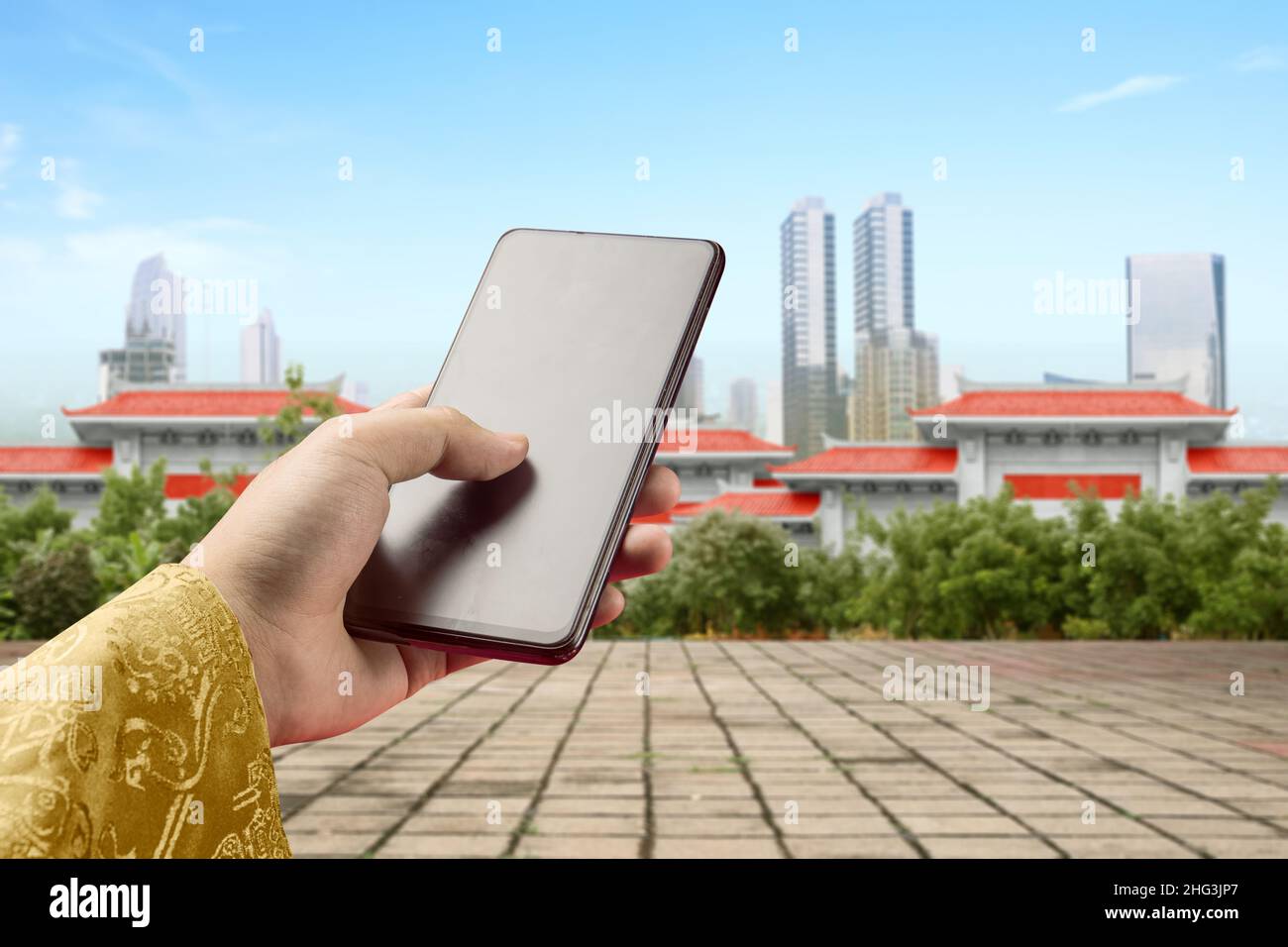 Hand holding mobile phone with Chinese pavilion gate background. Happy ...