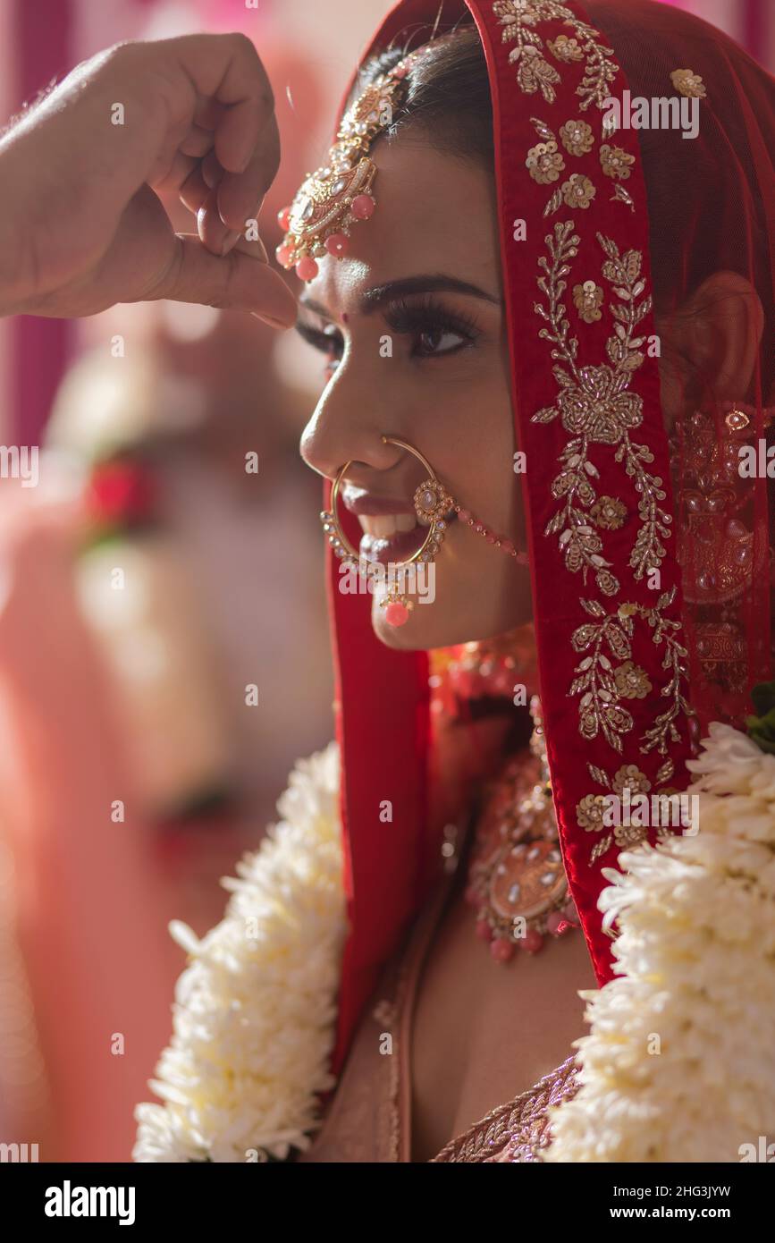 Indian groom putting sindoor on brides forehead during wedding ceremony ...