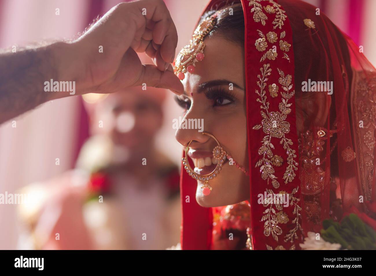 Indian groom putting sindoor on brides forehead during wedding ceremony ...
