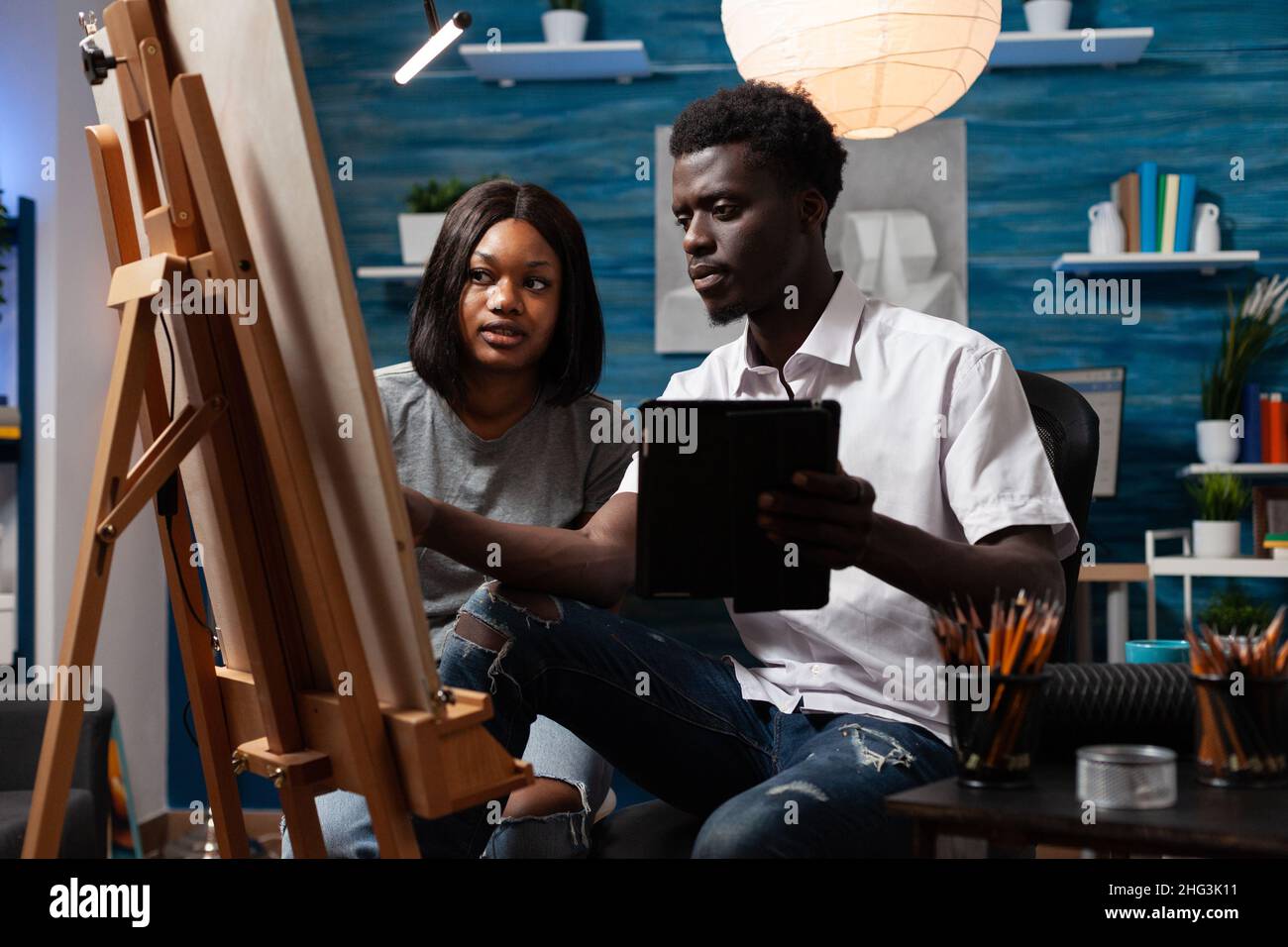 Creative students looking at draw inspiration on tablet sketching vase ...