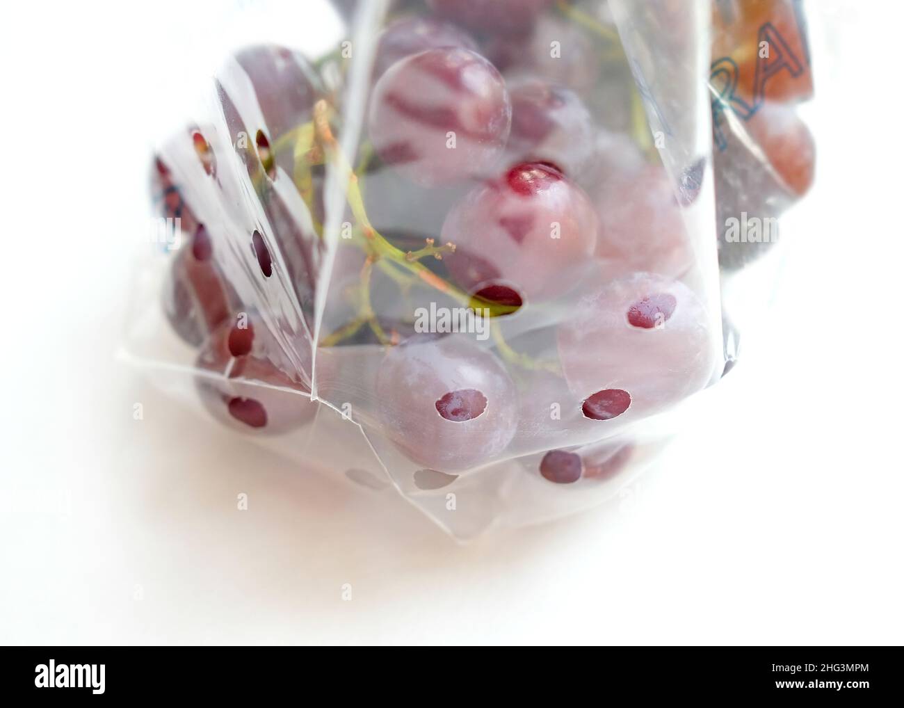 Unwashed grapes from the market in a package. Light background Stock ...