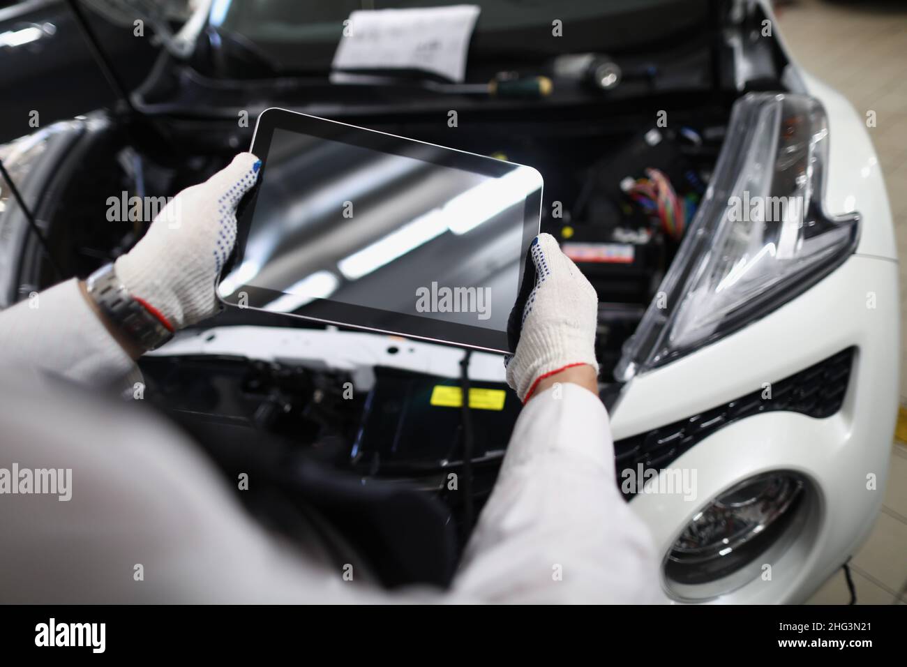 Mechanic use tablet device with black screen in front of car Stock ...