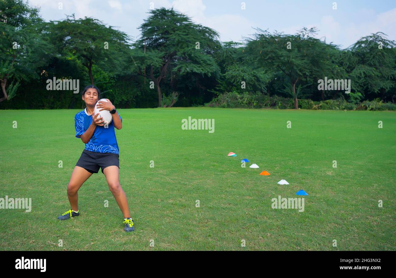 Young athlete girl practicing rugby on the sports field Stock Photo - Alamy