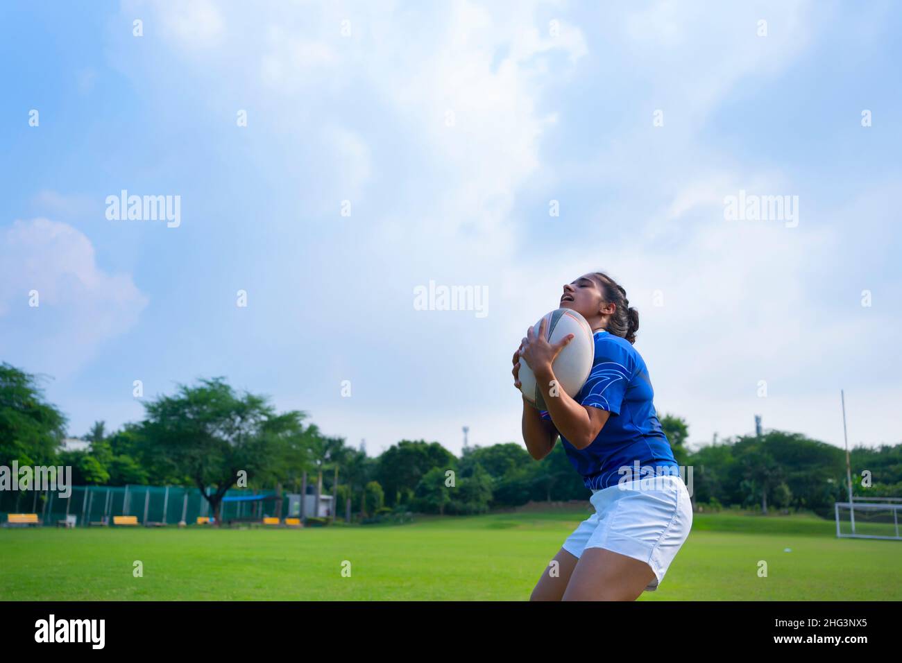 Young athlete girl practicing rugby on the sports field Stock Photo - Alamy