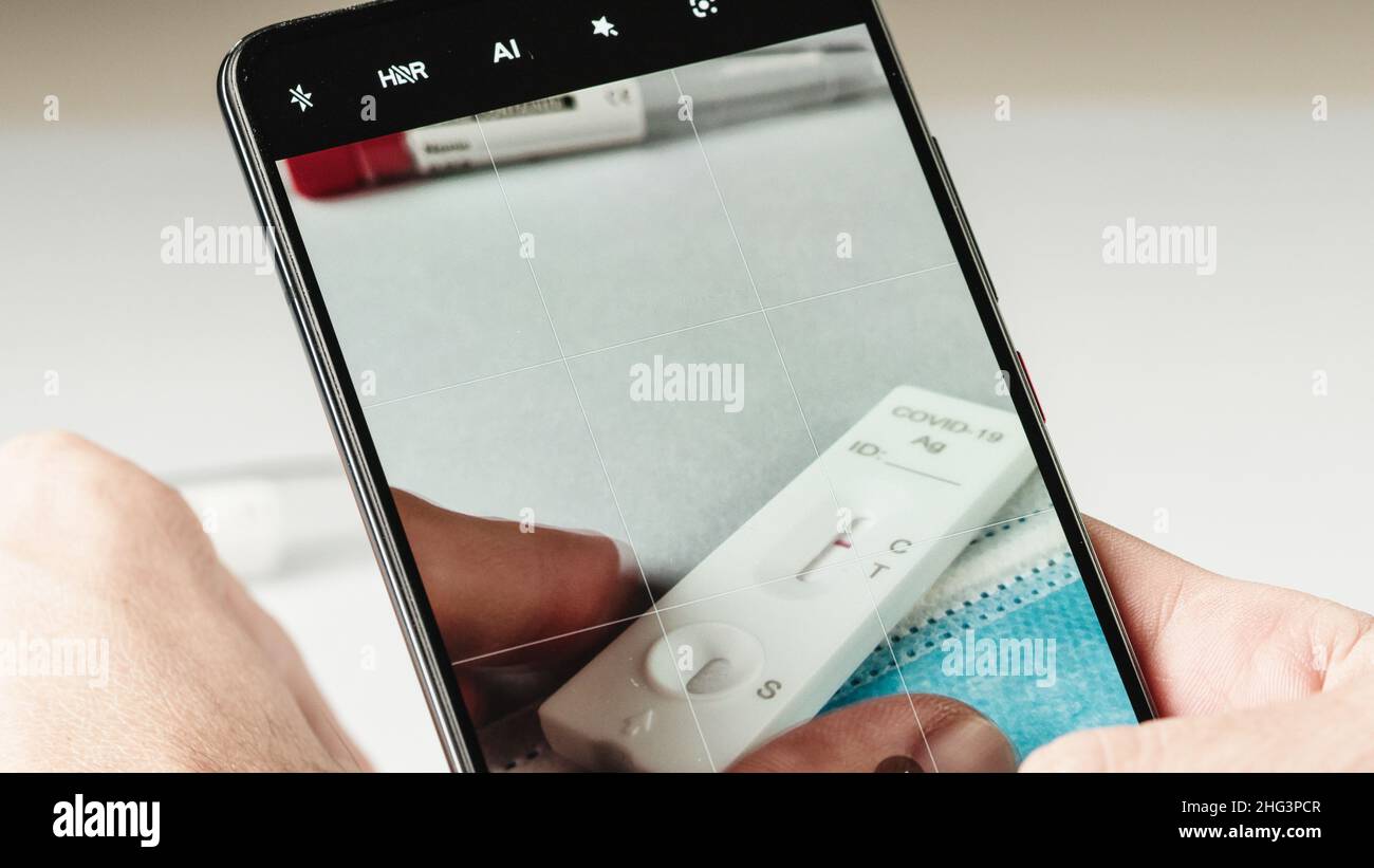 A Man photographs negative swab with smartphone Stock Photo - Alamy