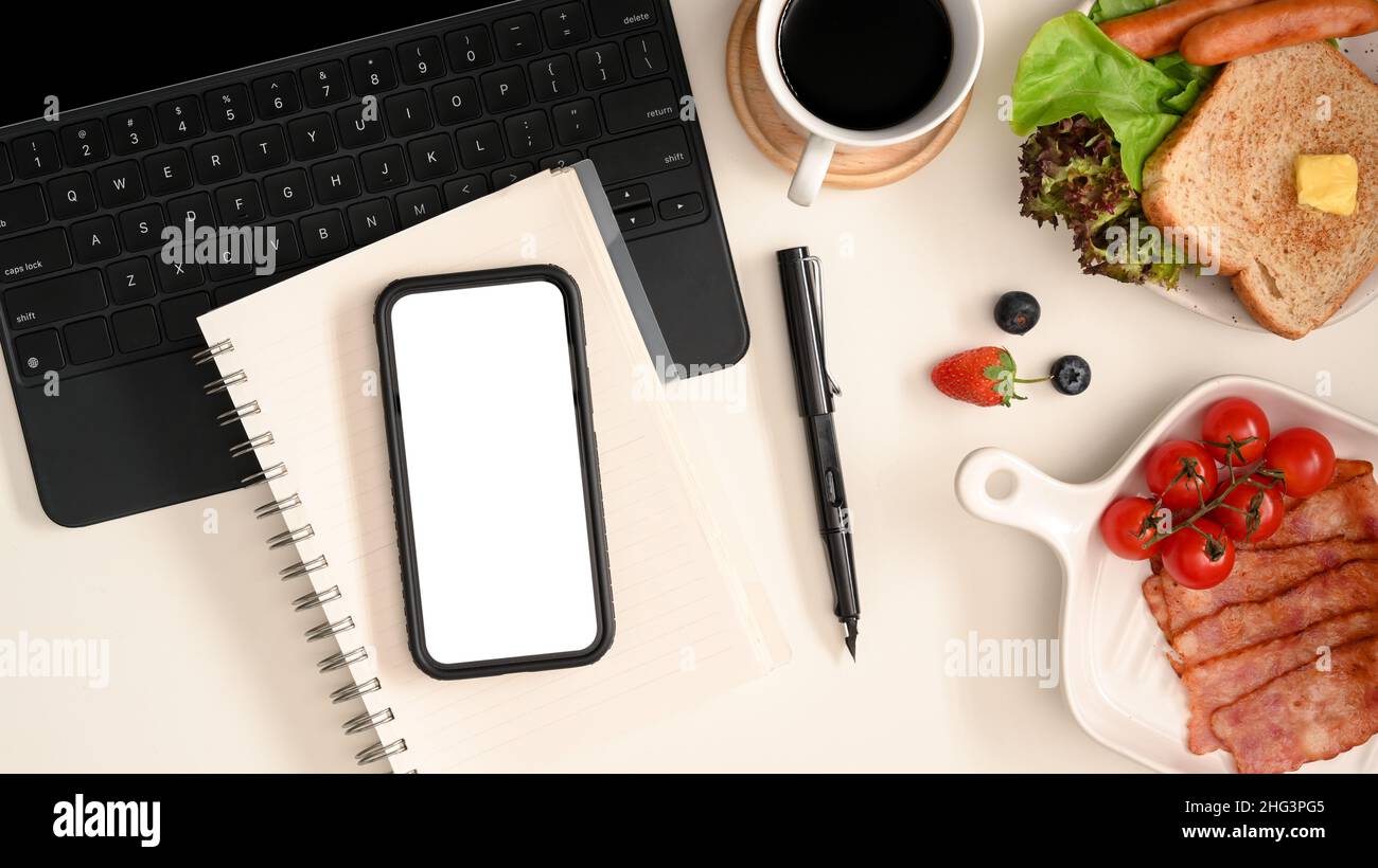 A smartphone white screen on workspace with tablet computer and ...