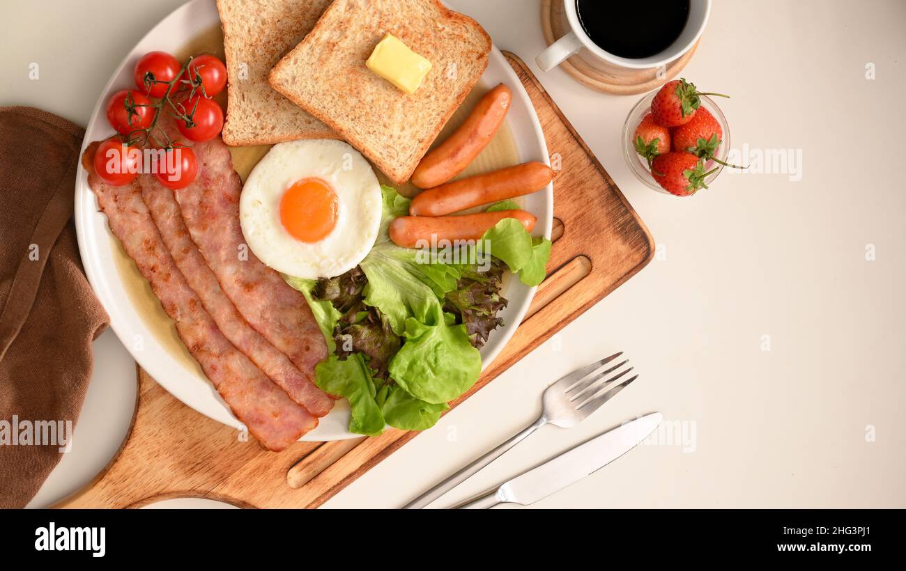 English breakfast set with egg, bacon, sausages, toasts and salad ...