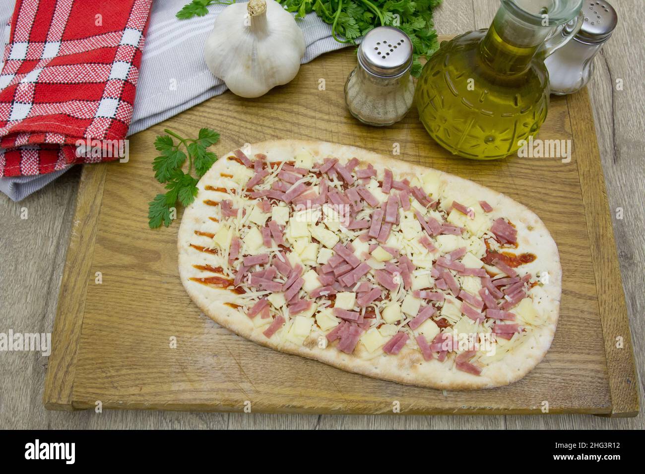pizza with ham and raw cheese on a wooden board Stock Photo - Alamy
