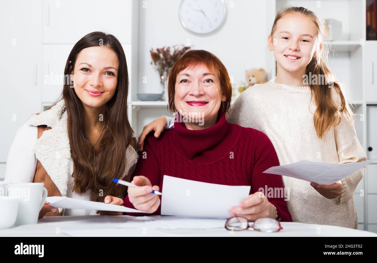 Smiling senior woman with family writing papers Stock Photo - Alamy