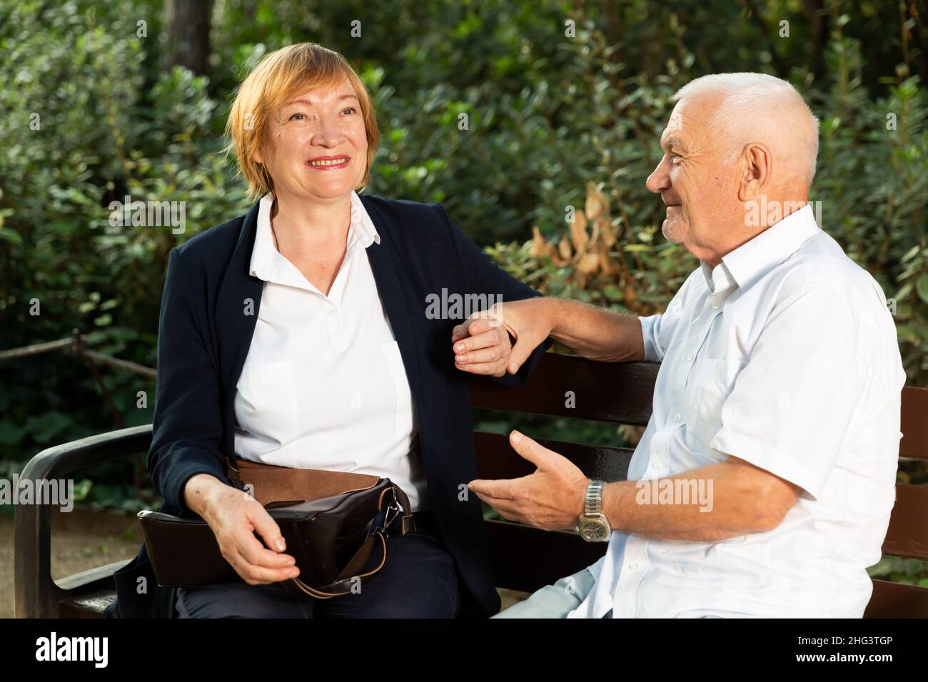 Elderly couple talking on bench Stock Photo - Alamy