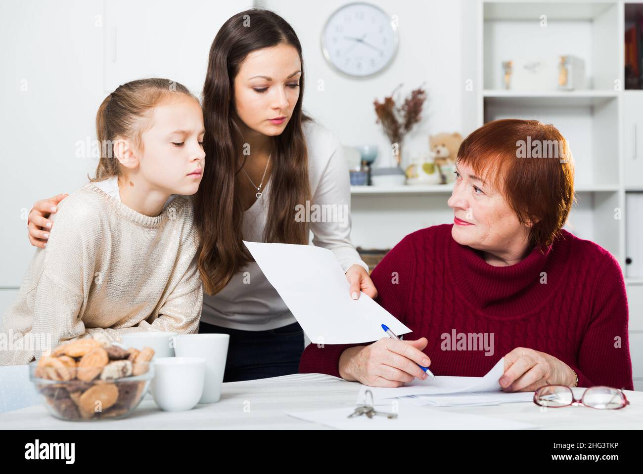 Adult daughter controlling signing of documents by grandmother Stock ...