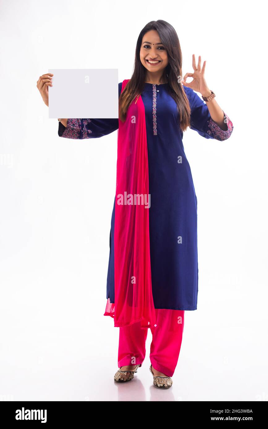 Young smiling woman holding a blank sheet of paper for advertising ...