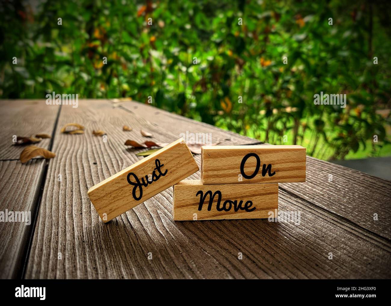Close up on text on wooden blocks - Just move on. With bench and park ...