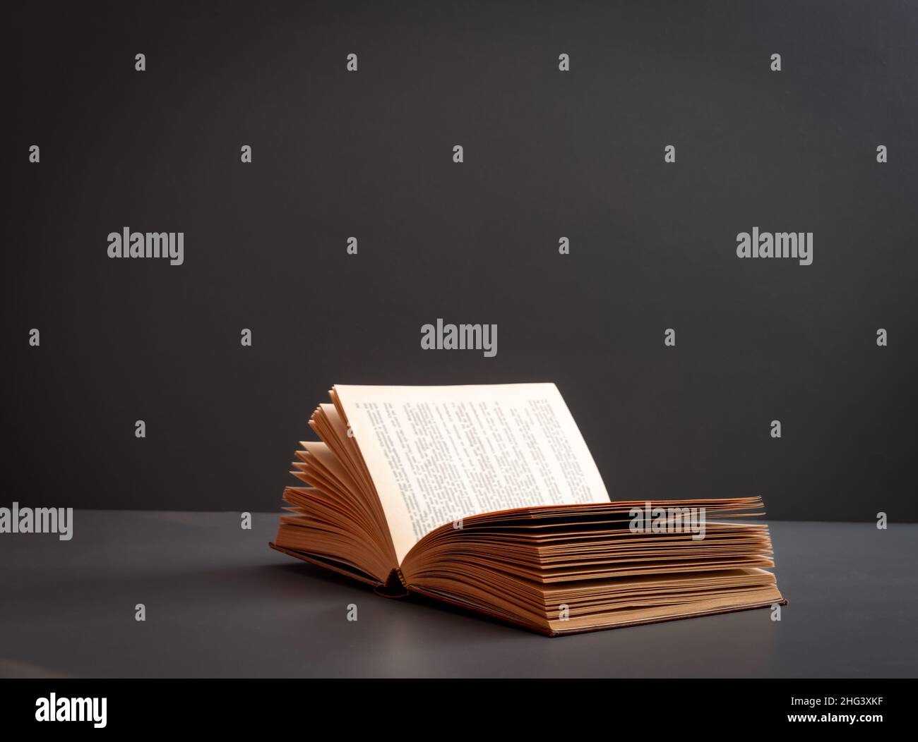 open old book on grey background showing blurred text Stock Photo - Alamy