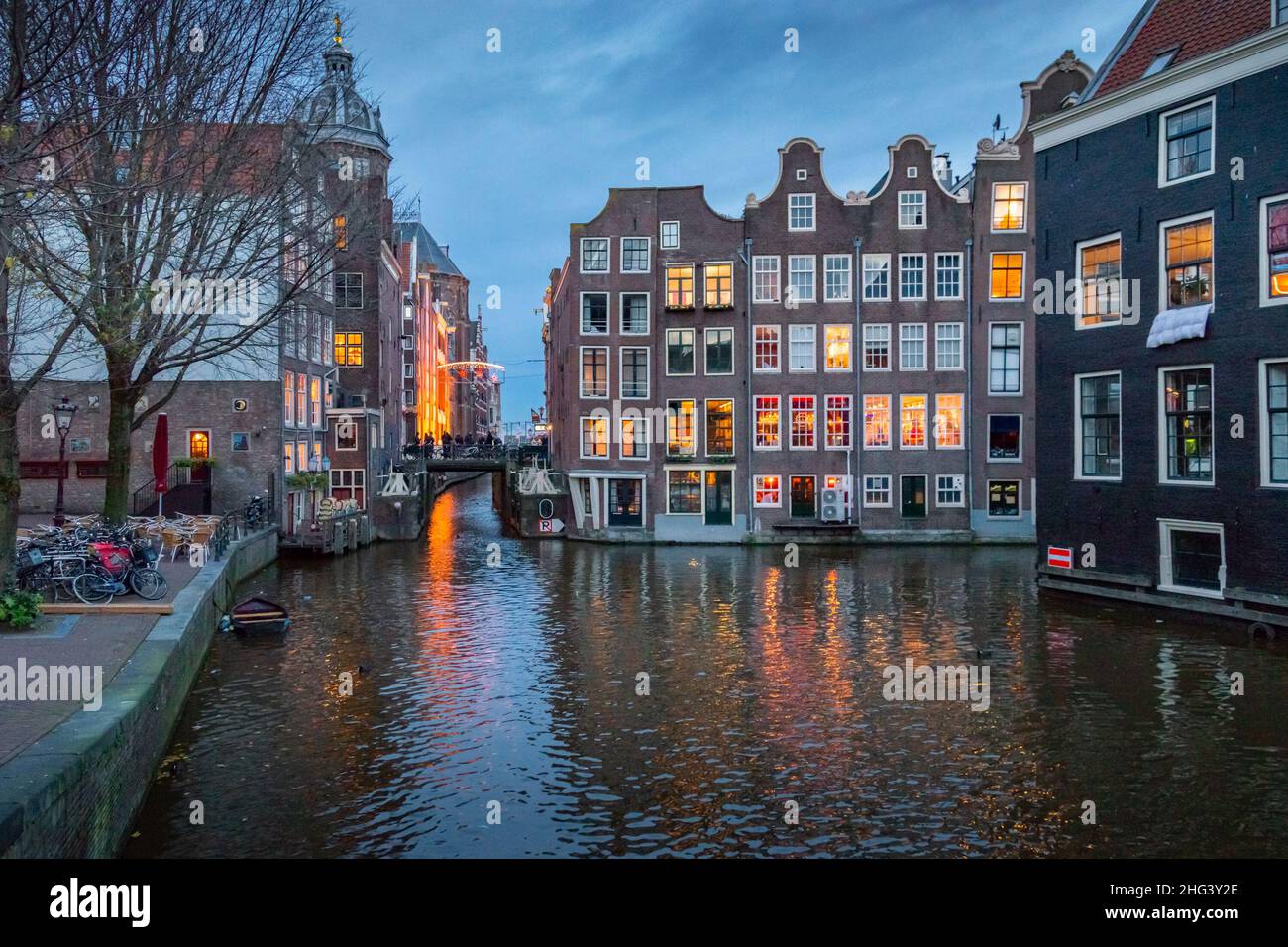 Amsterdam buildings at dusk with water canals and light reflections ...