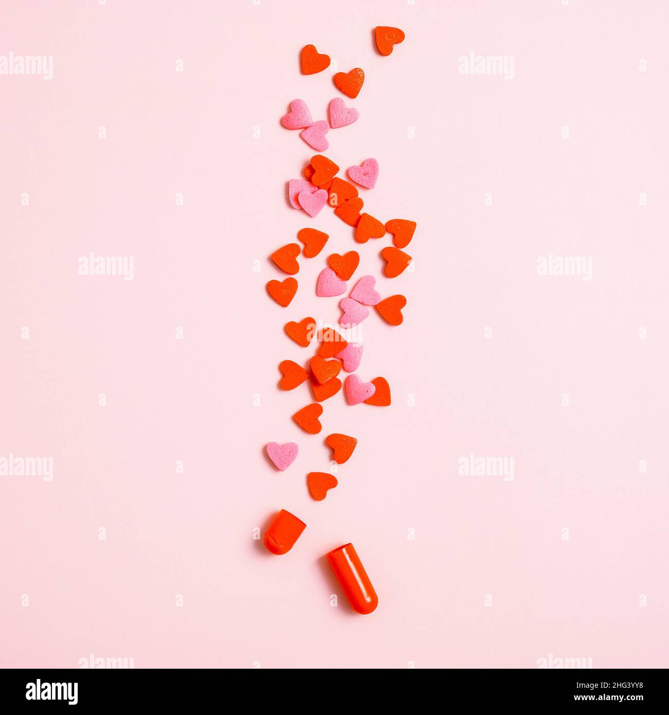 Split pill with hearts on pink background. Love pill tablet capsule ...