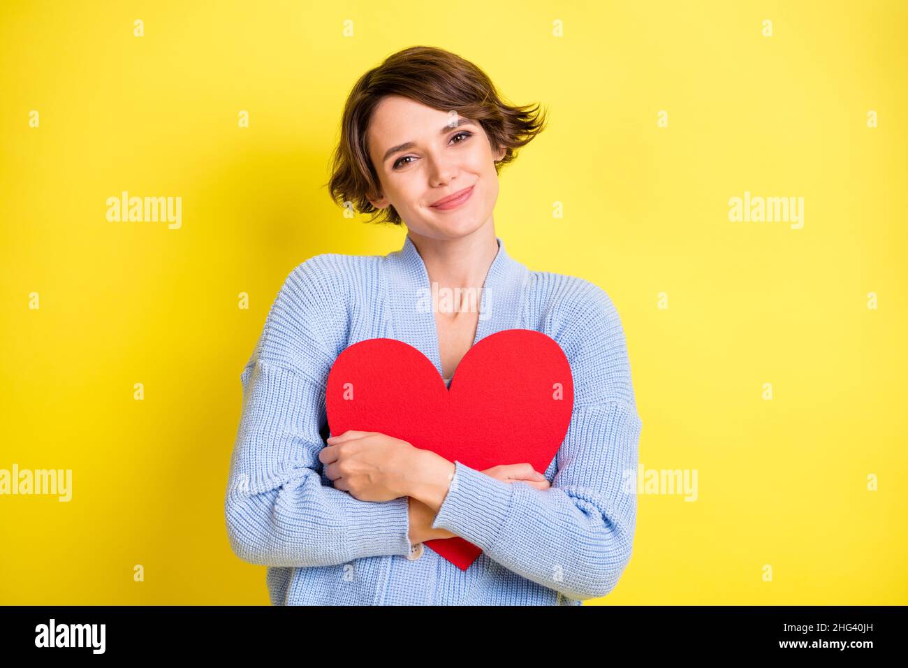 Portrait of attractive sweet kind careful girl hugging paper heart ...
