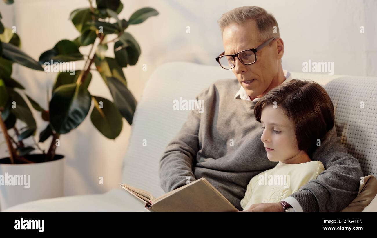 Grandpa reading to grandchild hi-res stock photography and images - Alamy