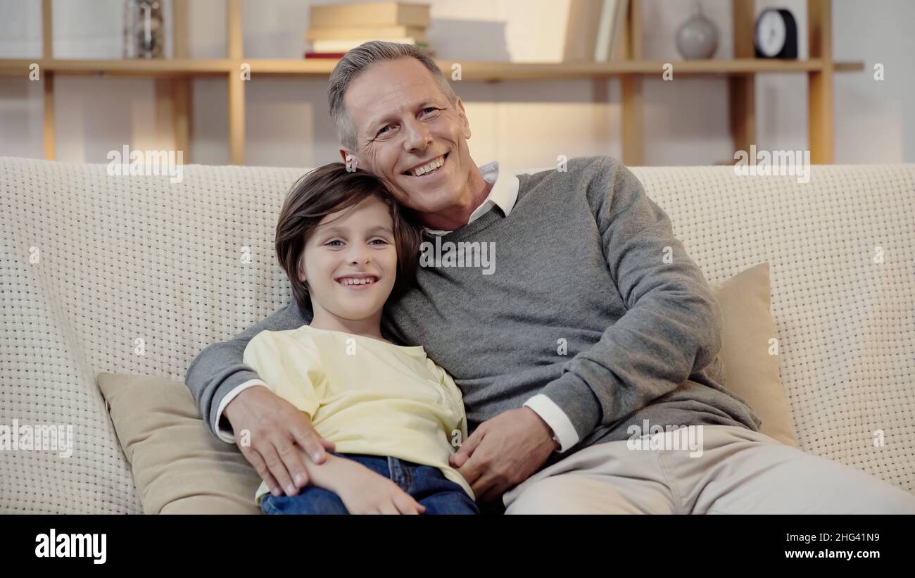 cheerful middle aged grandfather smiling with happy grandson Stock ...