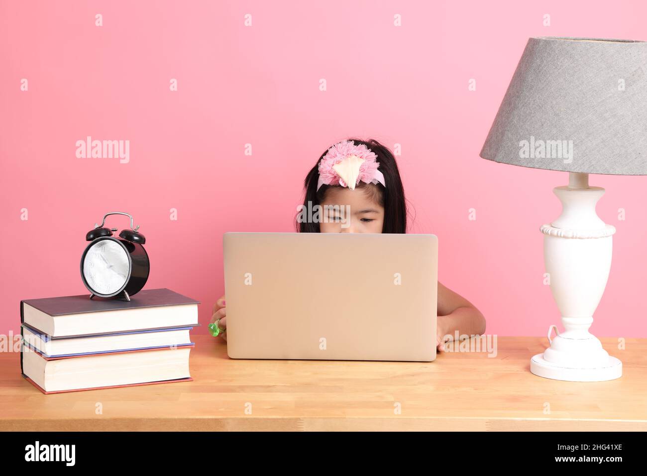 The cute Asian girl learning from internet by laptop with the pink ...