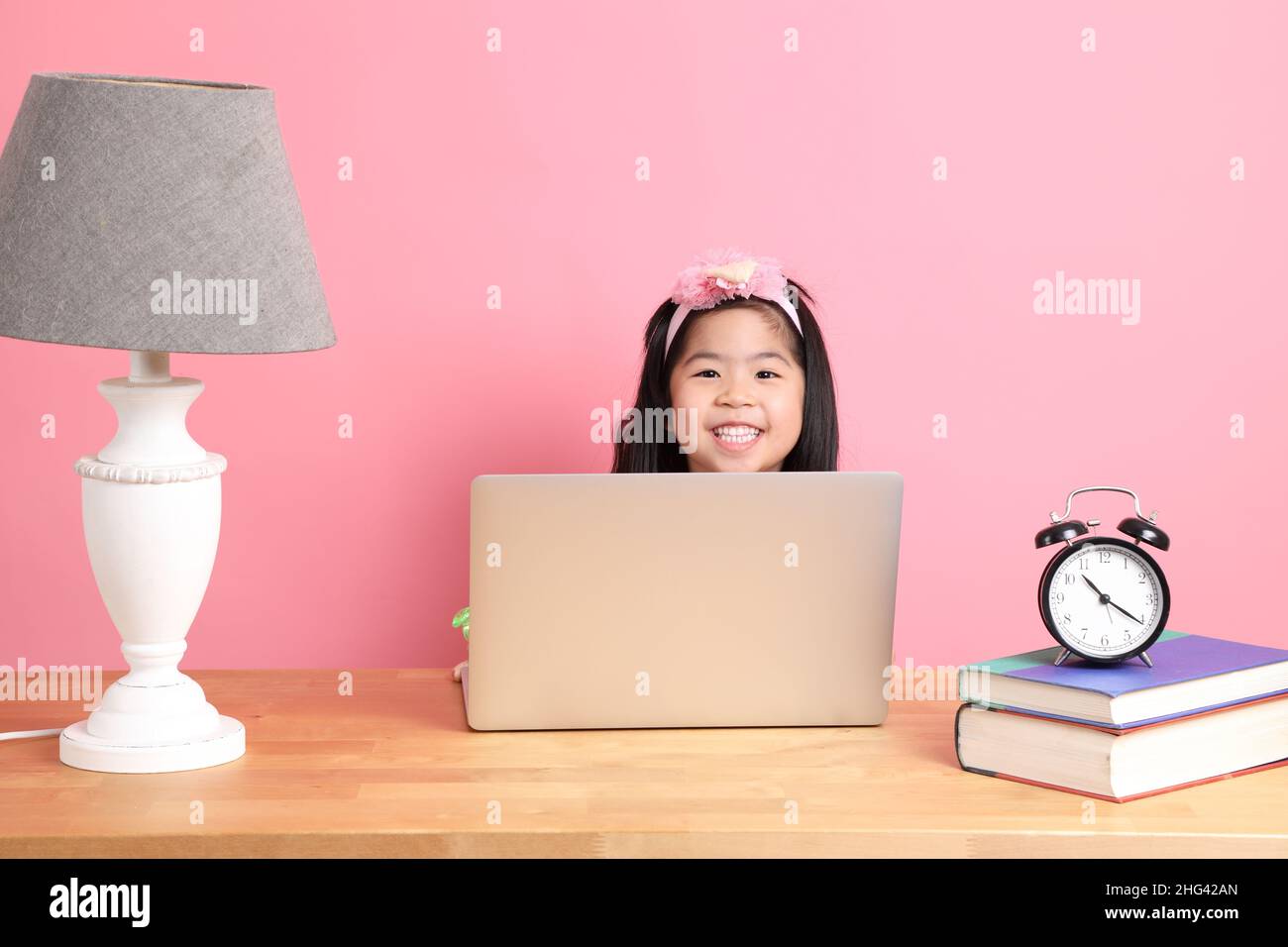 The cute Asian girl learning from internet by laptop with the pink ...