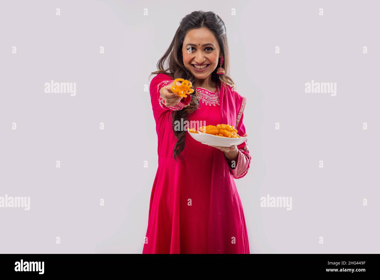 Indian woman in pink salwar offering Jalebi on festival Stock Photo - Alamy