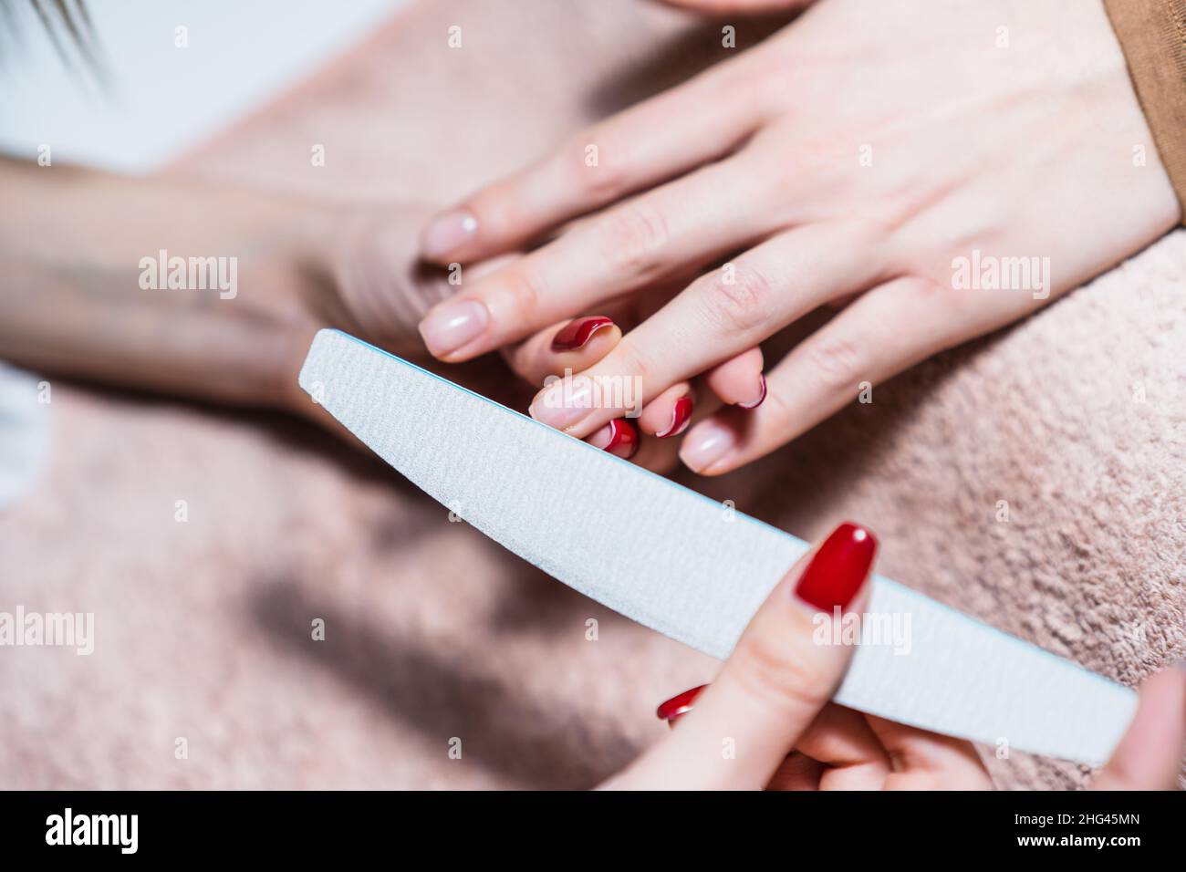 Close up image of manicure process, manicurist using nail file on ...