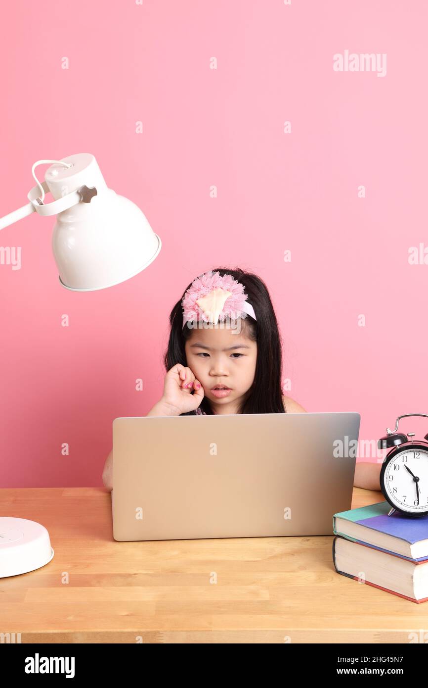 The cute Asian girl learning from internet by laptop with the pink ...