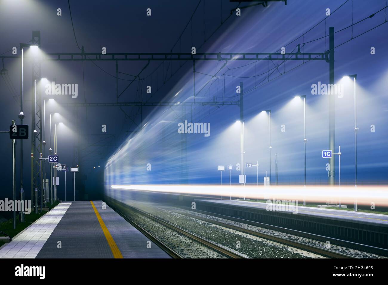 Railway at night. Light trail of passenger train at illuminated ...