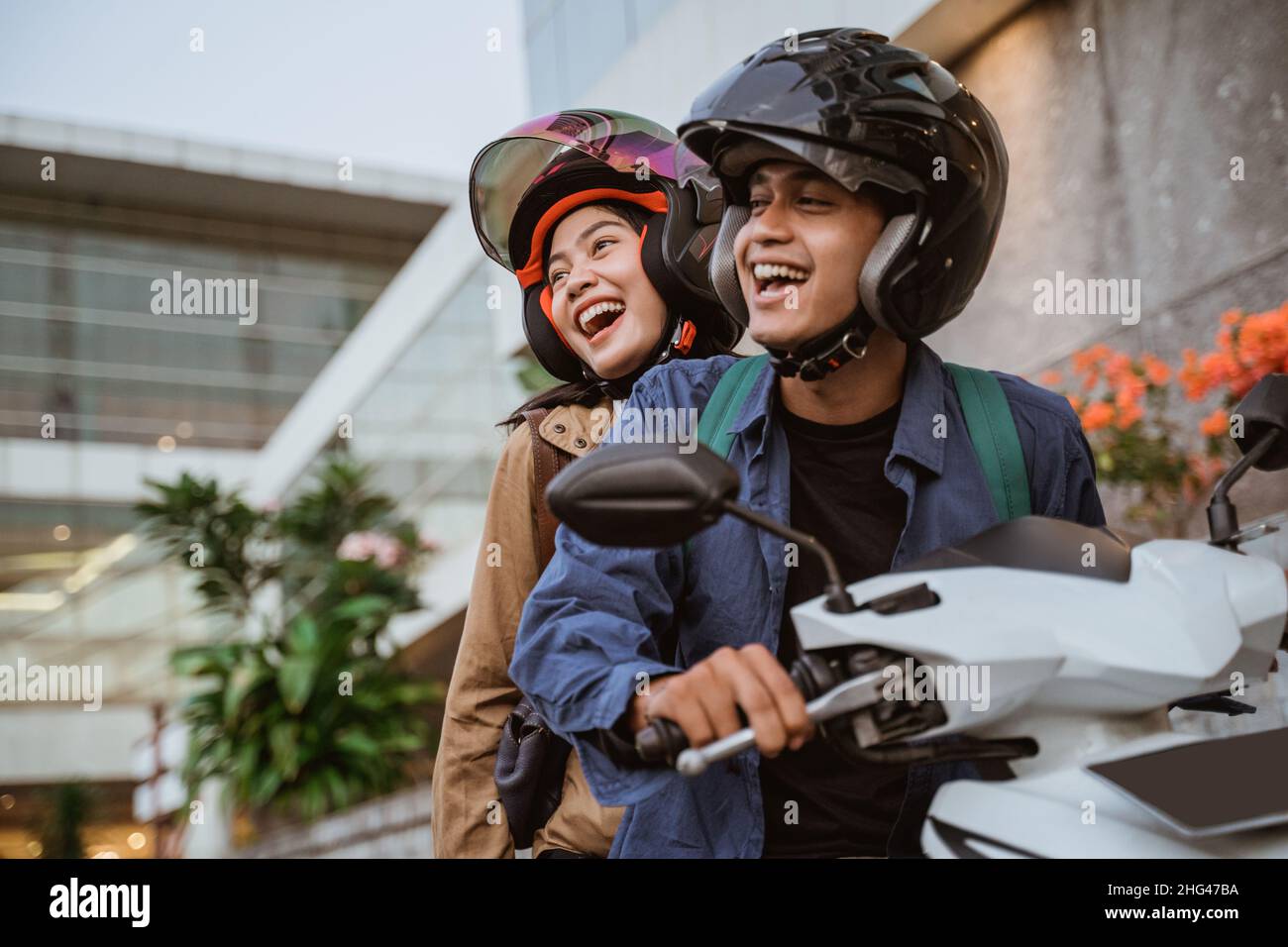 a man and woman laughing while riding a motorcycle Stock Photo - Alamy