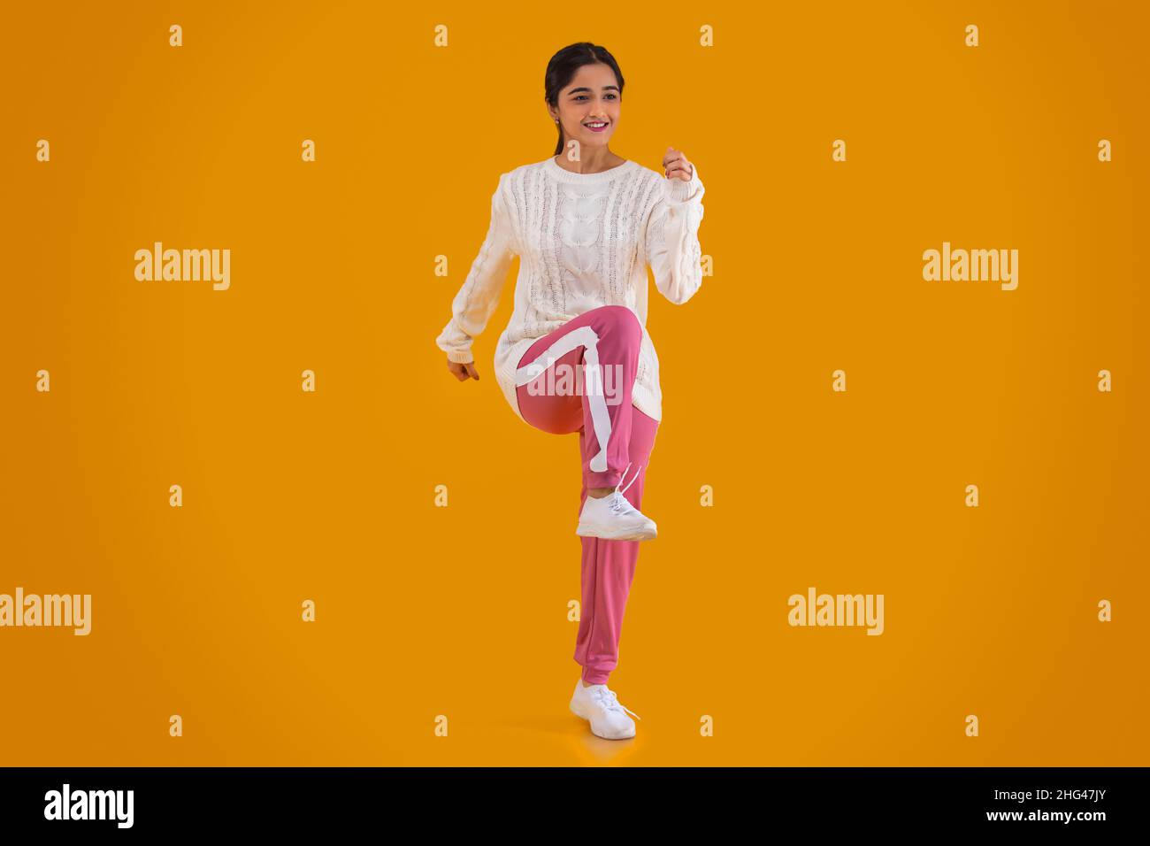 Active young girl in sports uniform exercising Stock Photo - Alamy