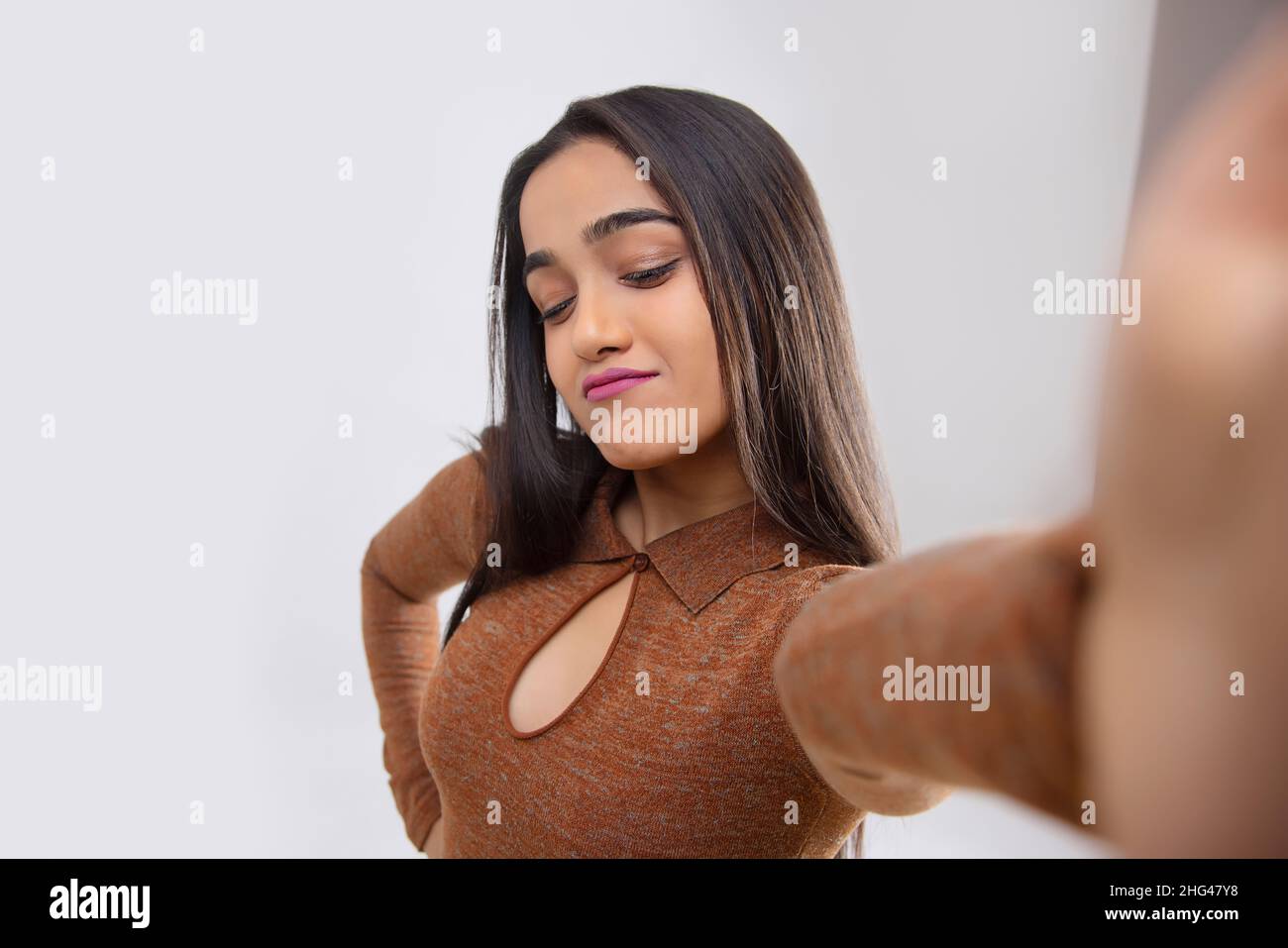 Young girl looking down while taking selfie Stock Photo - Alamy